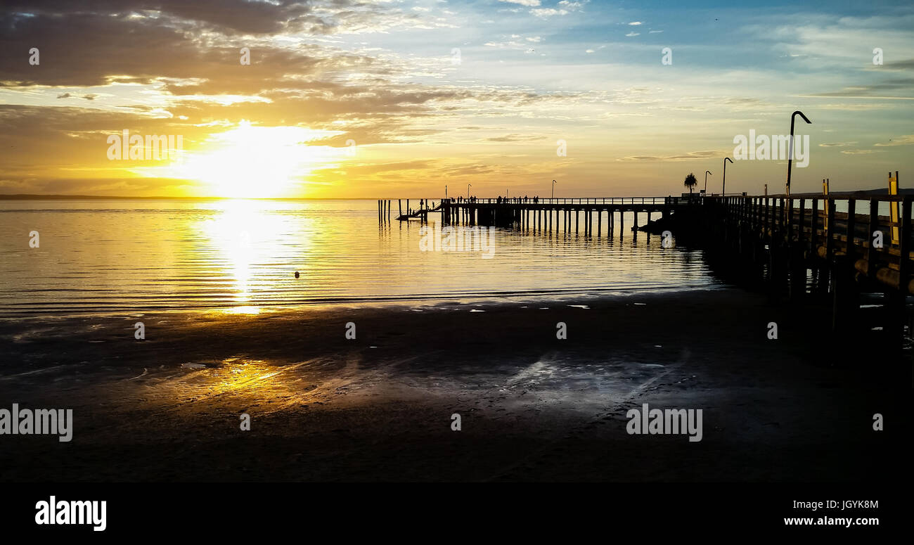Landing jetty at sunset with colourful clouds at on Fraser Island ...