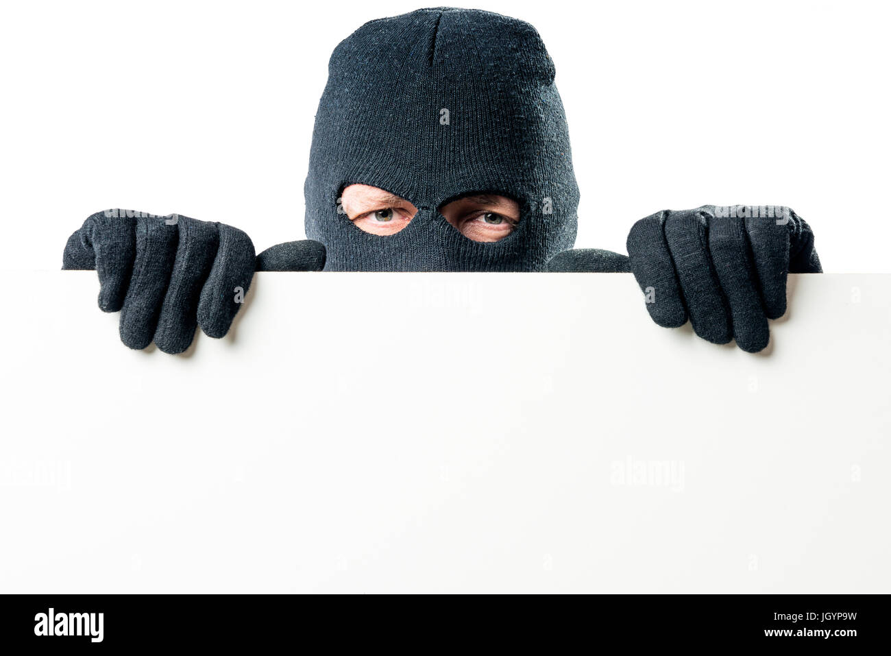 Portrait of the criminal in the mask with a large poster for the ...