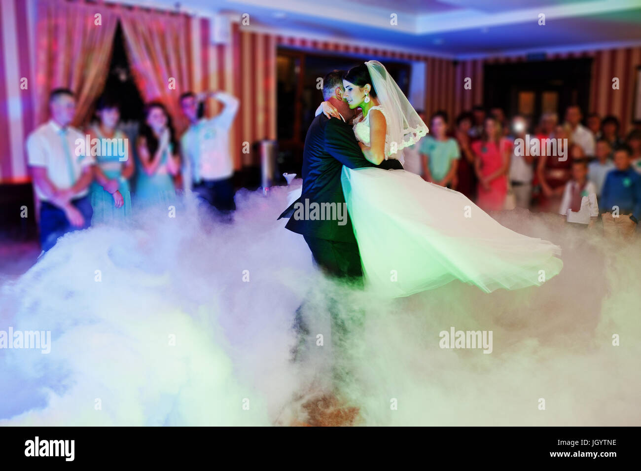 Beautiful couple dancing in the restaurant with different lights and ...