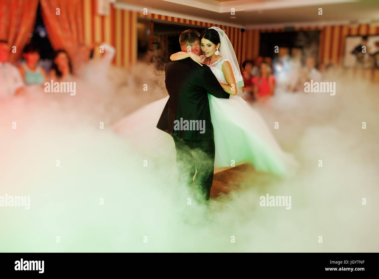 Beautiful couple dancing in the restaurant with different lights and ...