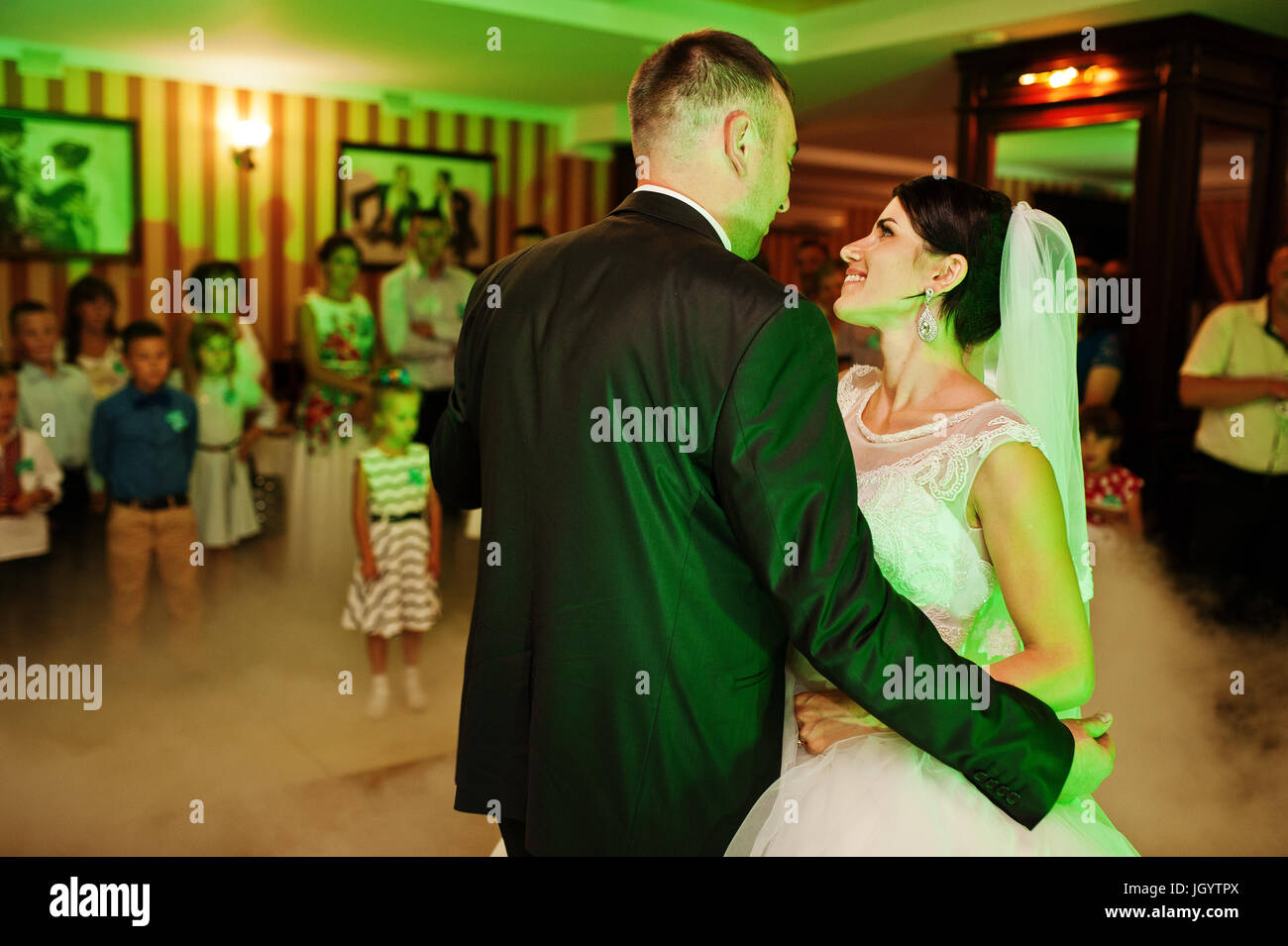 Beautiful couple dancing in the restaurant with different lights and ...