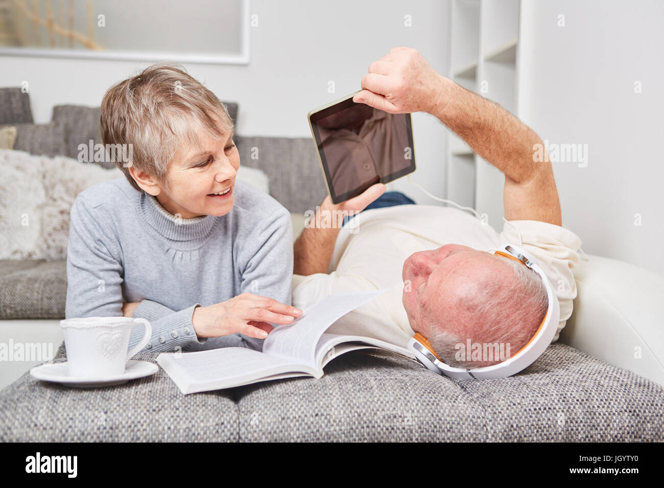Senior couple in retirement reading ebook and book with enjoyment Stock ...