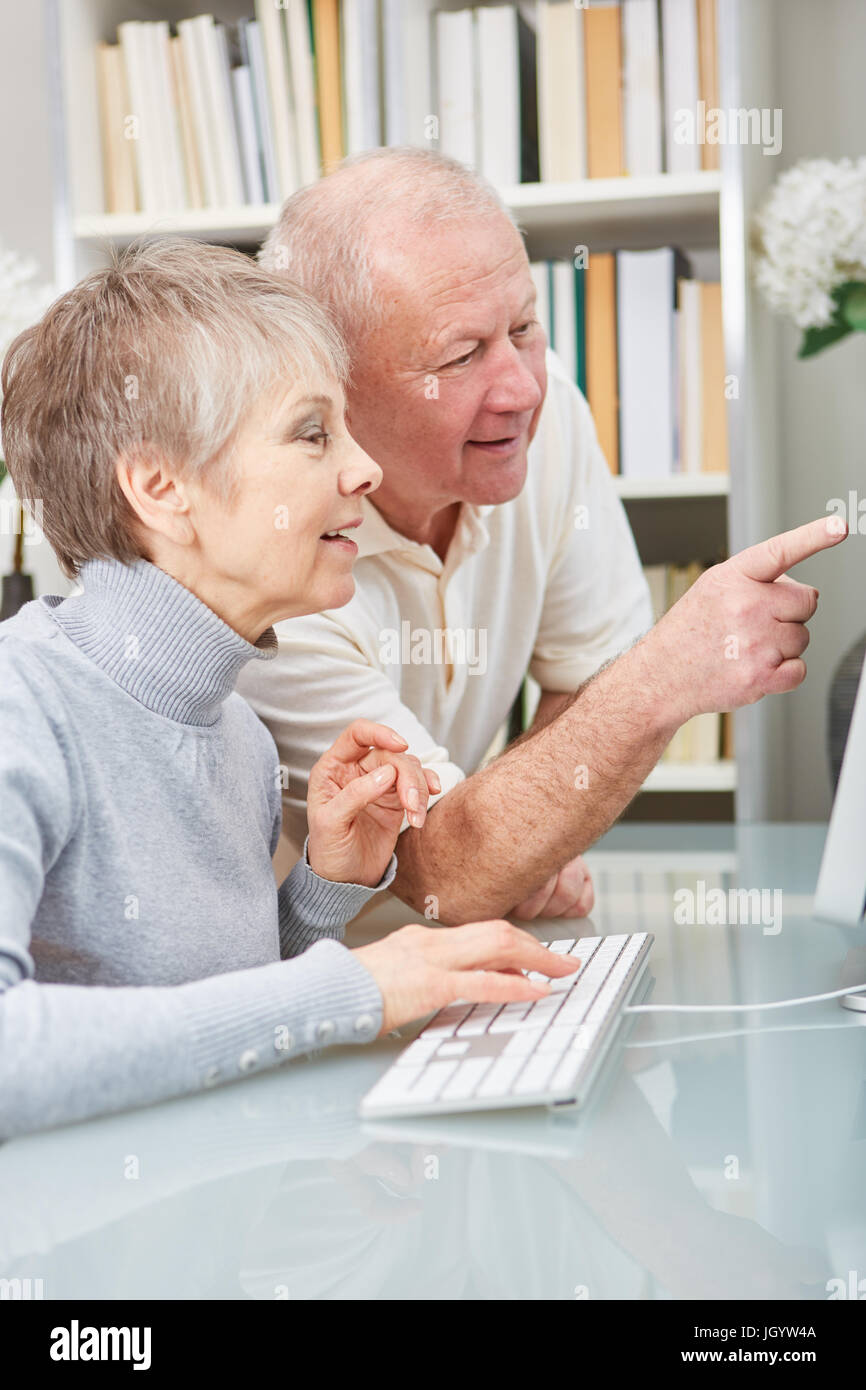 Seniors looking at computer monitor with curiosity Stock Photo - Alamy