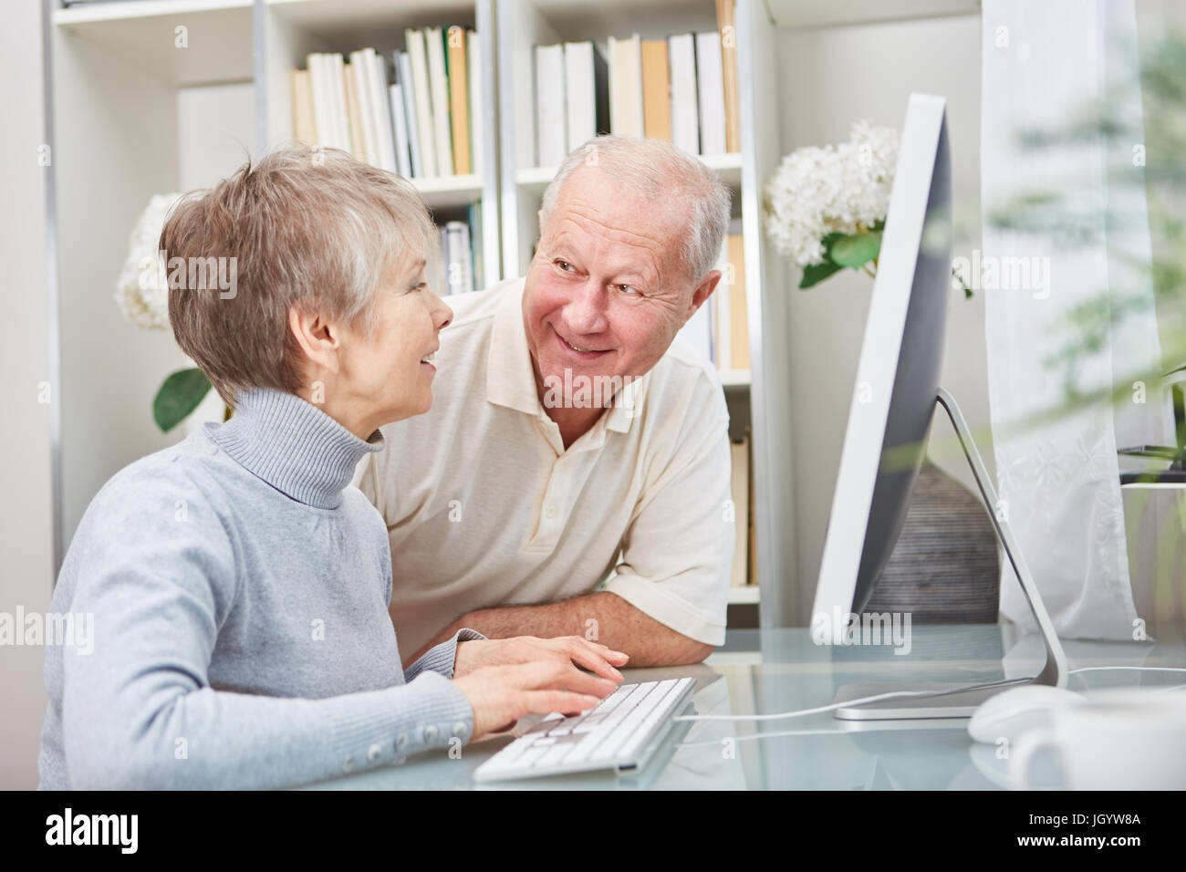 Seniors learn how to use computer together in teamwork Stock Photo - Alamy