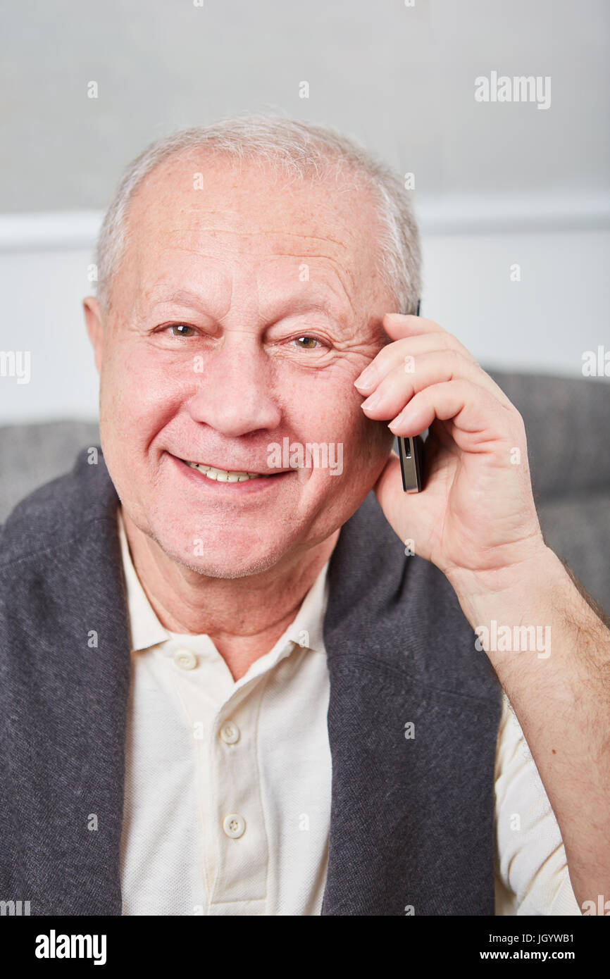 Happy senior man calling with smartphone at his home Stock Photo - Alamy