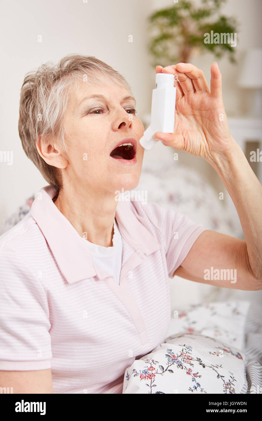 Senior woman with asthma using inhaler Stock Photo - Alamy