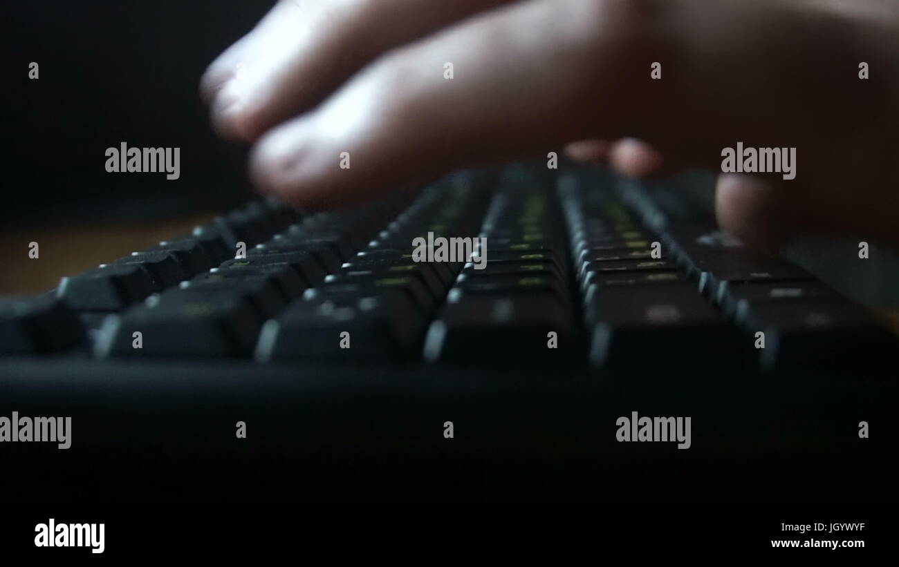 human hands working on the keyboard,dark room Stock Photo - Alamy