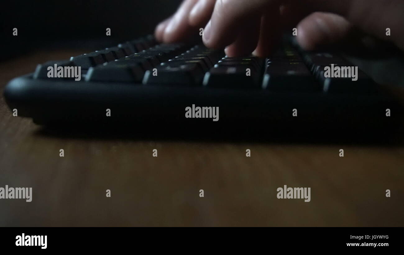 human hands working on the keyboard,dark room Stock Photo - Alamy
