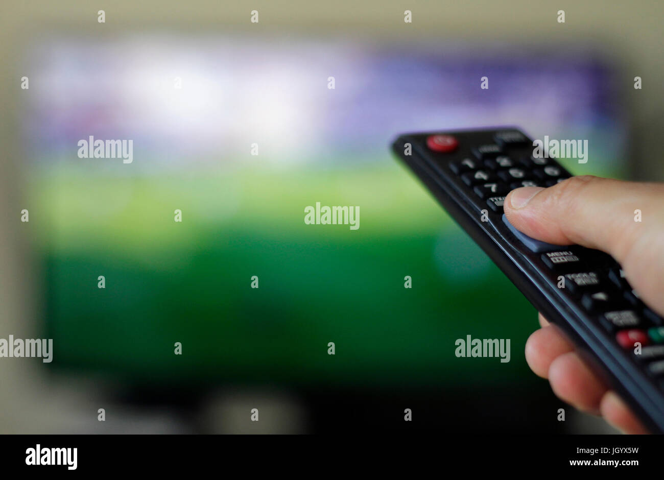 Hand with TV remote control Stock Photo - Alamy