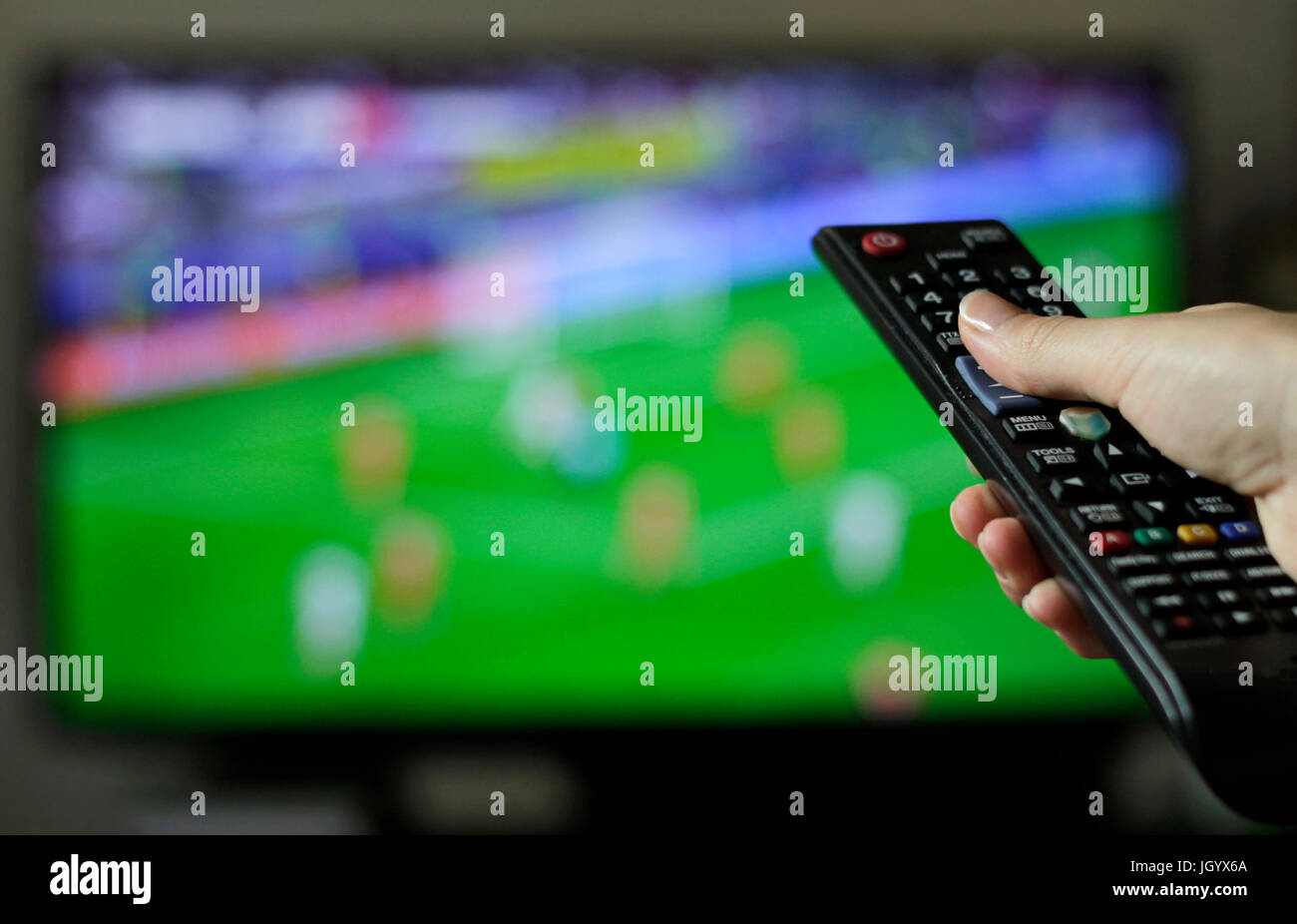 Hand with TV remote control Stock Photo - Alamy
