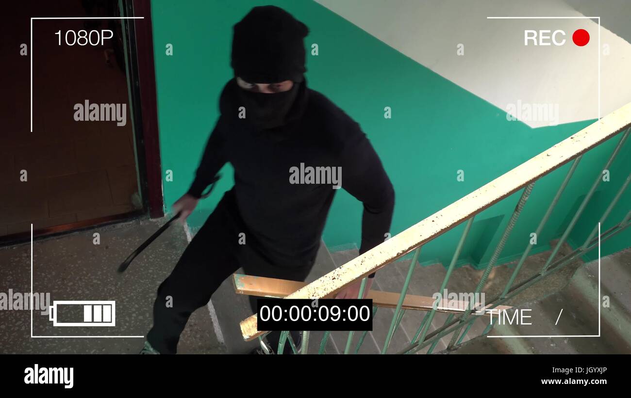 surveillance camera caught the robber in a mask with a crowbar Stock ...