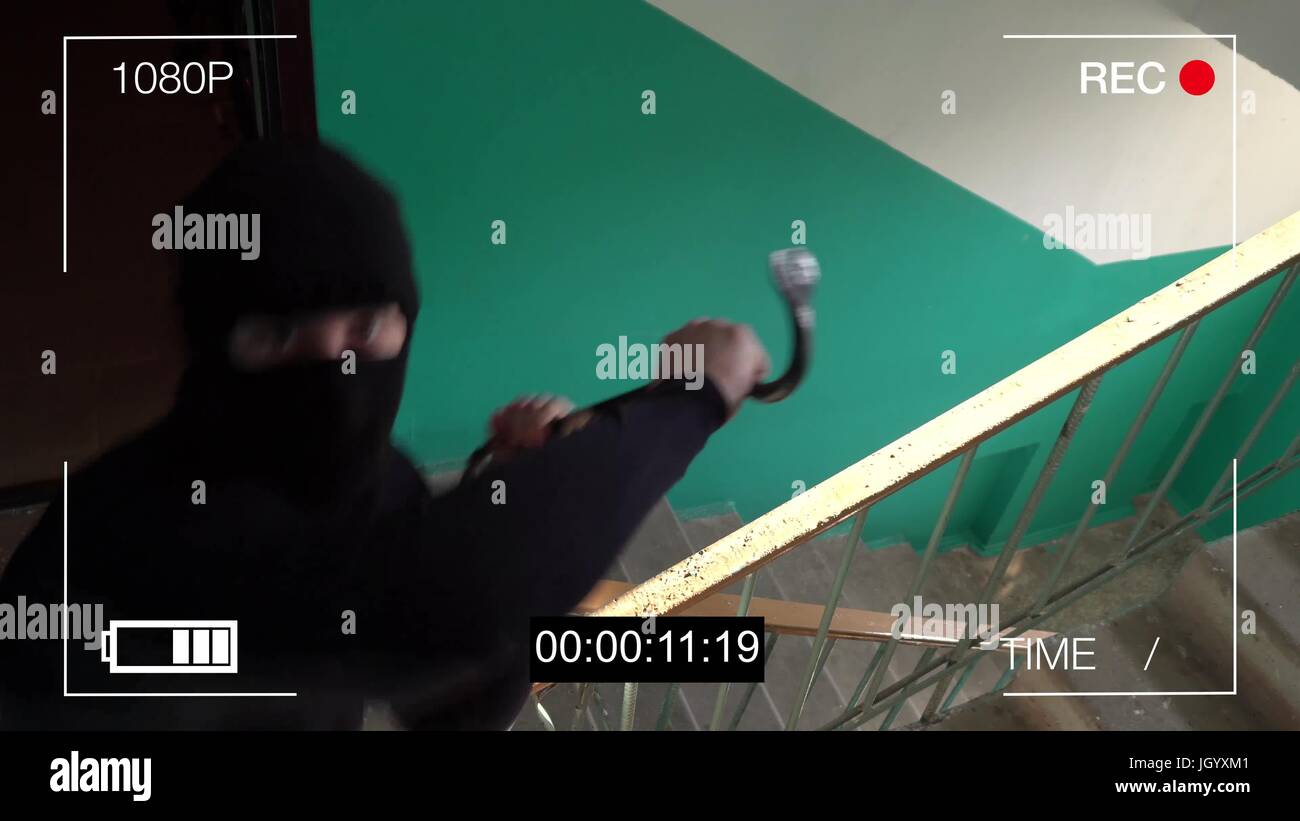 the masked robber breaks removing the surveillance camera mount Stock ...