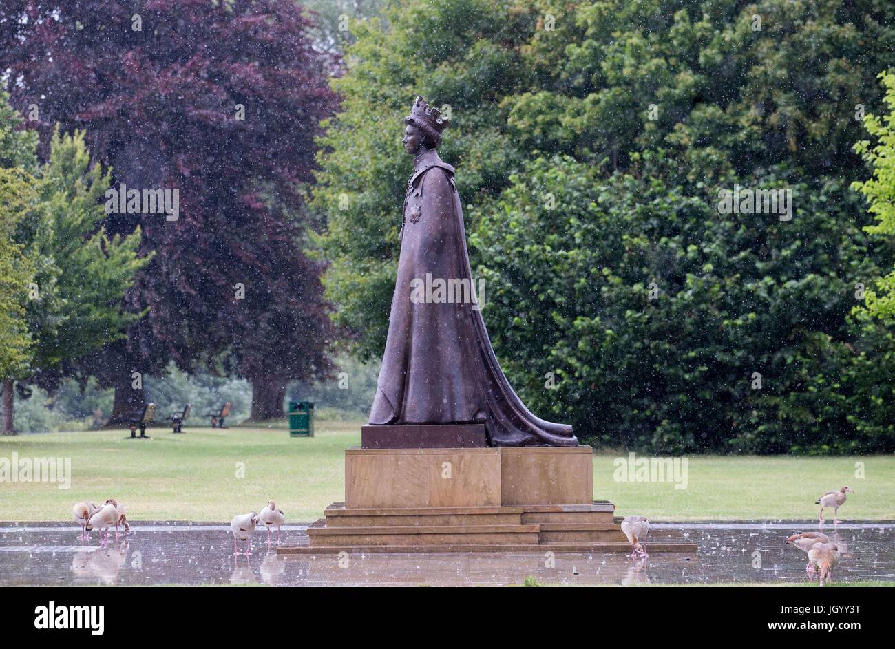 Ducks in a puddle around a statue of Queen Elizabeth II in the rain in ...