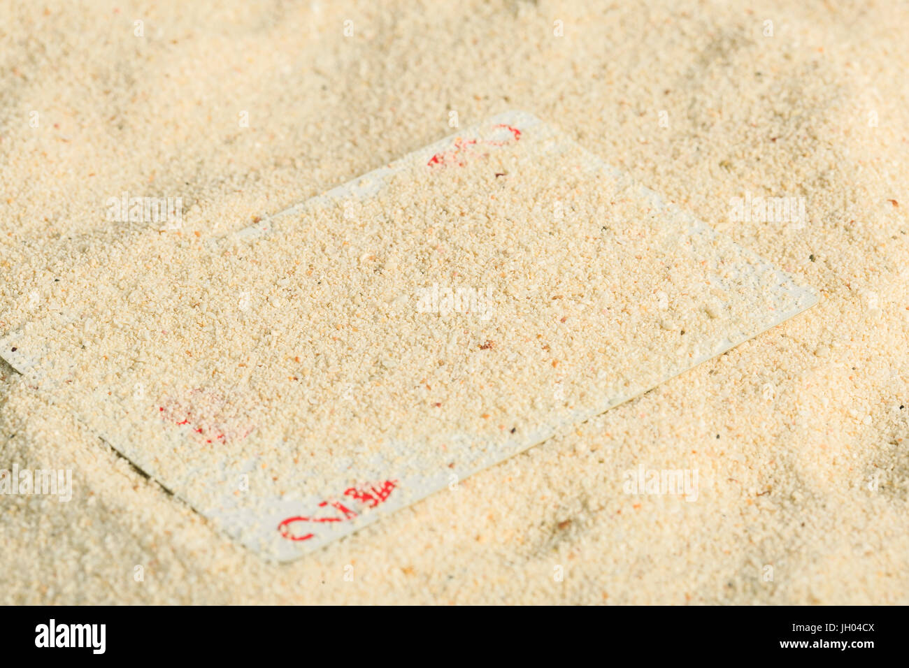 Poker playing cards buried in a sand dune Stock Photo - Alamy