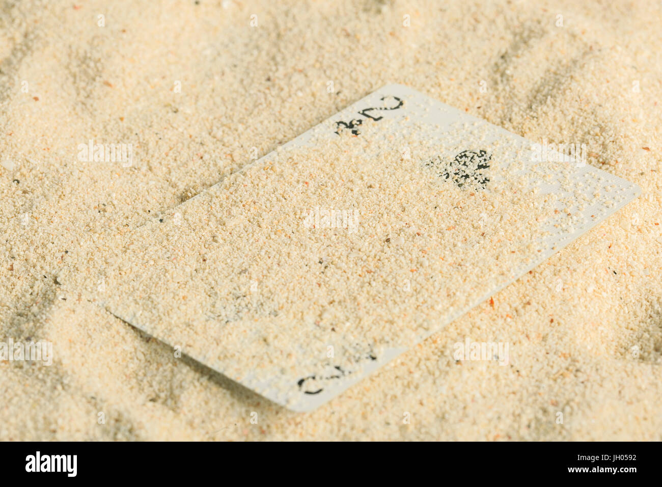 Poker playing cards buried in a sand dune Stock Photo - Alamy
