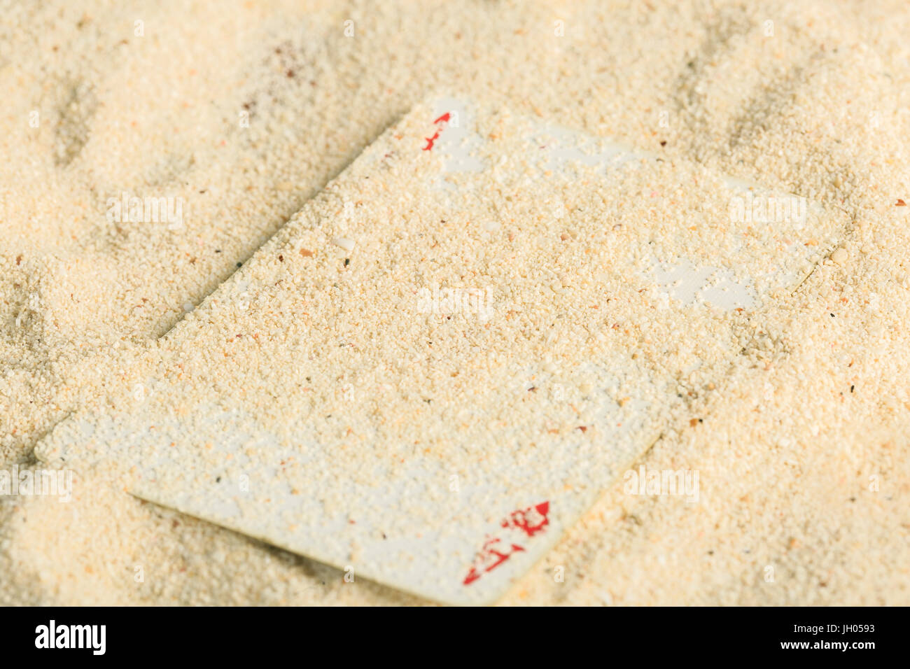 Poker playing cards buried in a sand dune Stock Photo - Alamy
