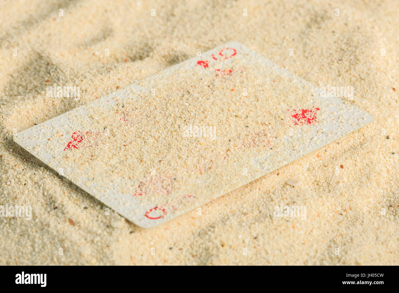 Poker playing cards buried in a sand dune Stock Photo - Alamy