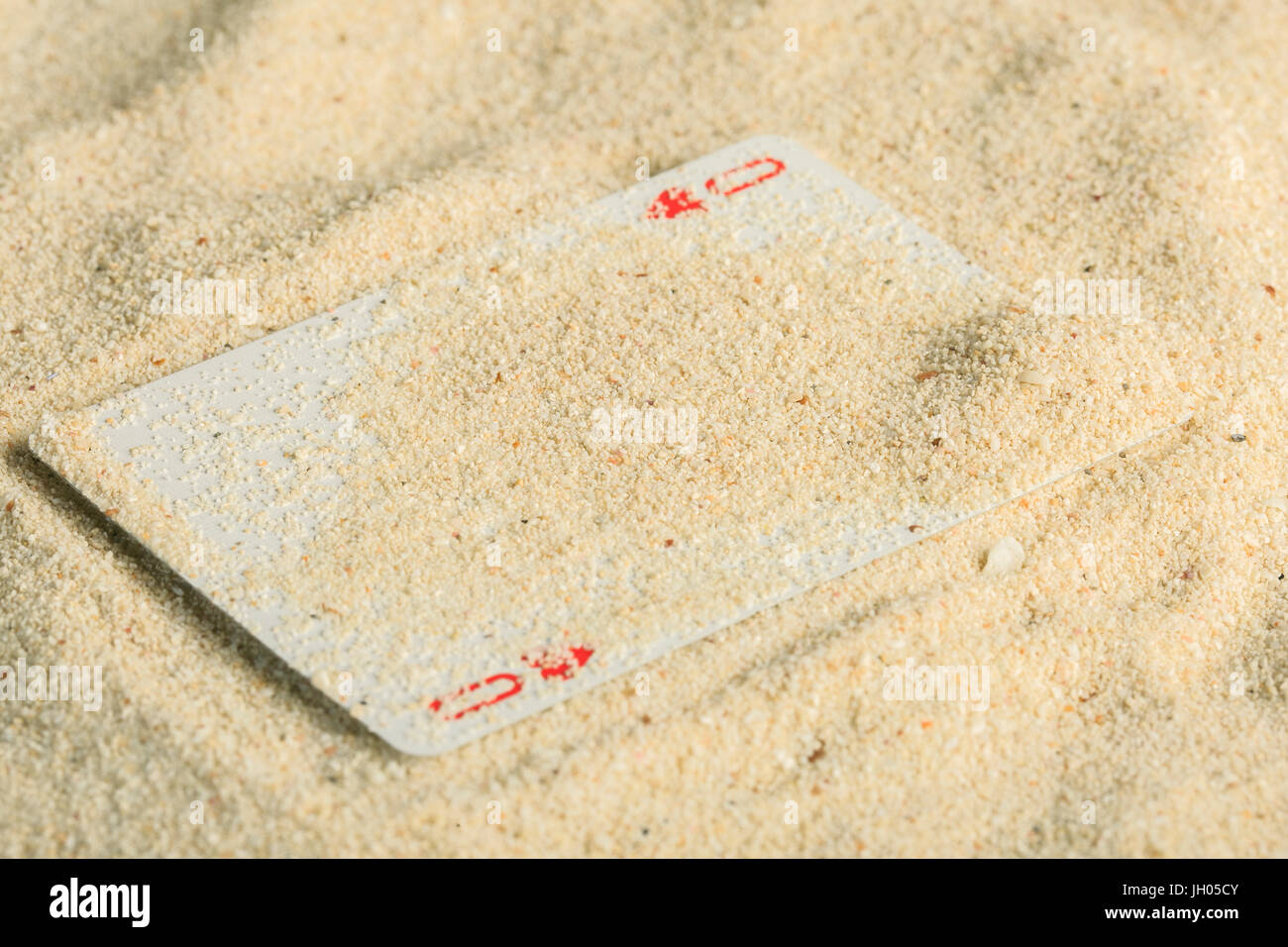 Poker playing cards buried in a sand dune Stock Photo - Alamy