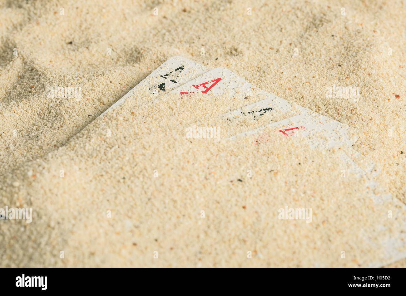 Poker playing cards buried in a sand dune Stock Photo - Alamy