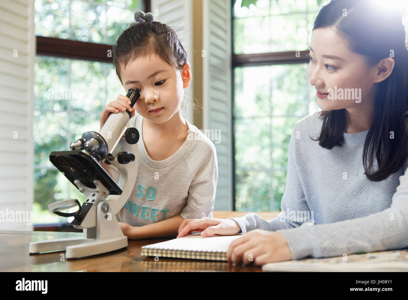 Mother and daughter using microscope Stock Photo - Alamy