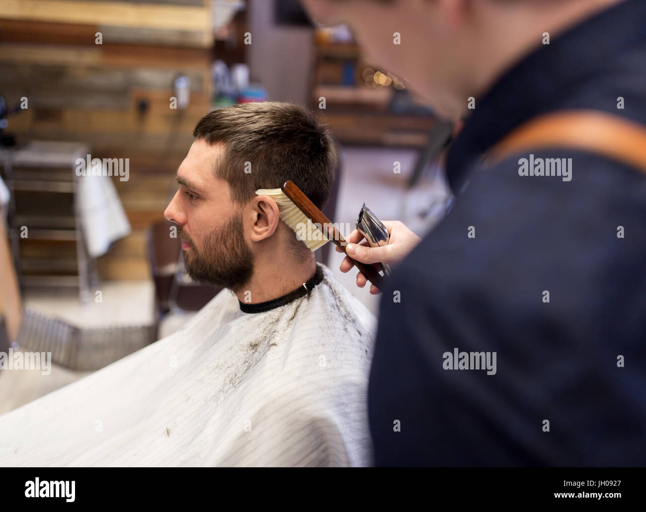 man and barber with brush cleaning hair at salon Stock Photo - Alamy
