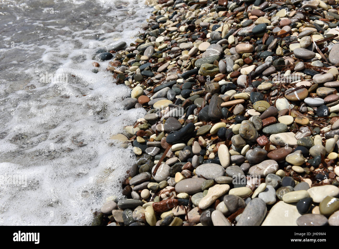 Sea waves approaching pebble stones on the beach Stock Photo - Alamy