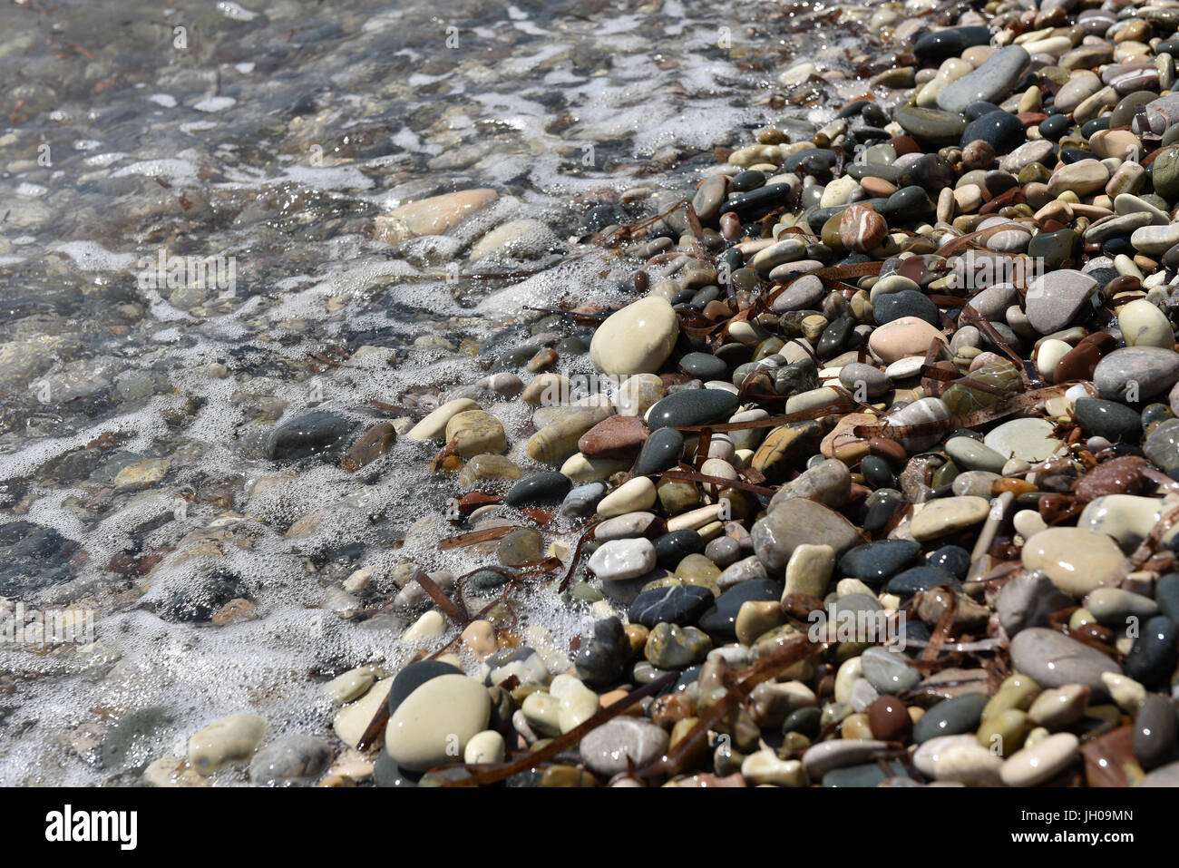 Sea waves approaching pebble stones on the beach Stock Photo - Alamy