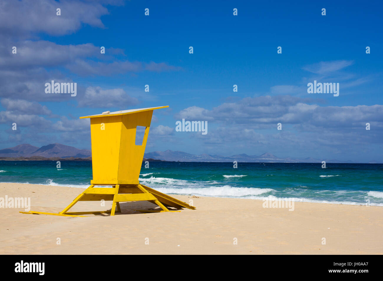 Yellow lifeguard tower. One life guard together red flag on beach ...