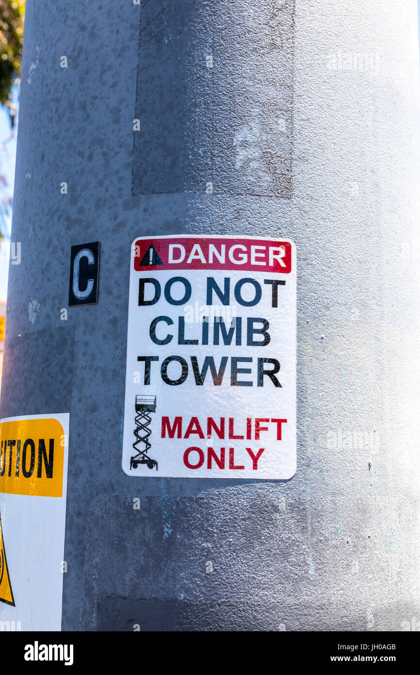 A cell phone tower in a parking lot of a group of retail stores with ...