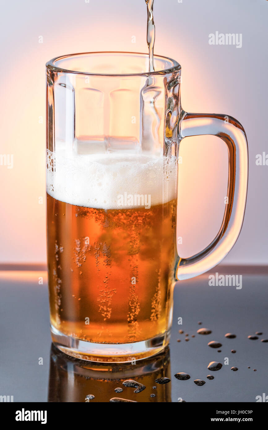 Stream of beer pours into the glass Stock Photo - Alamy