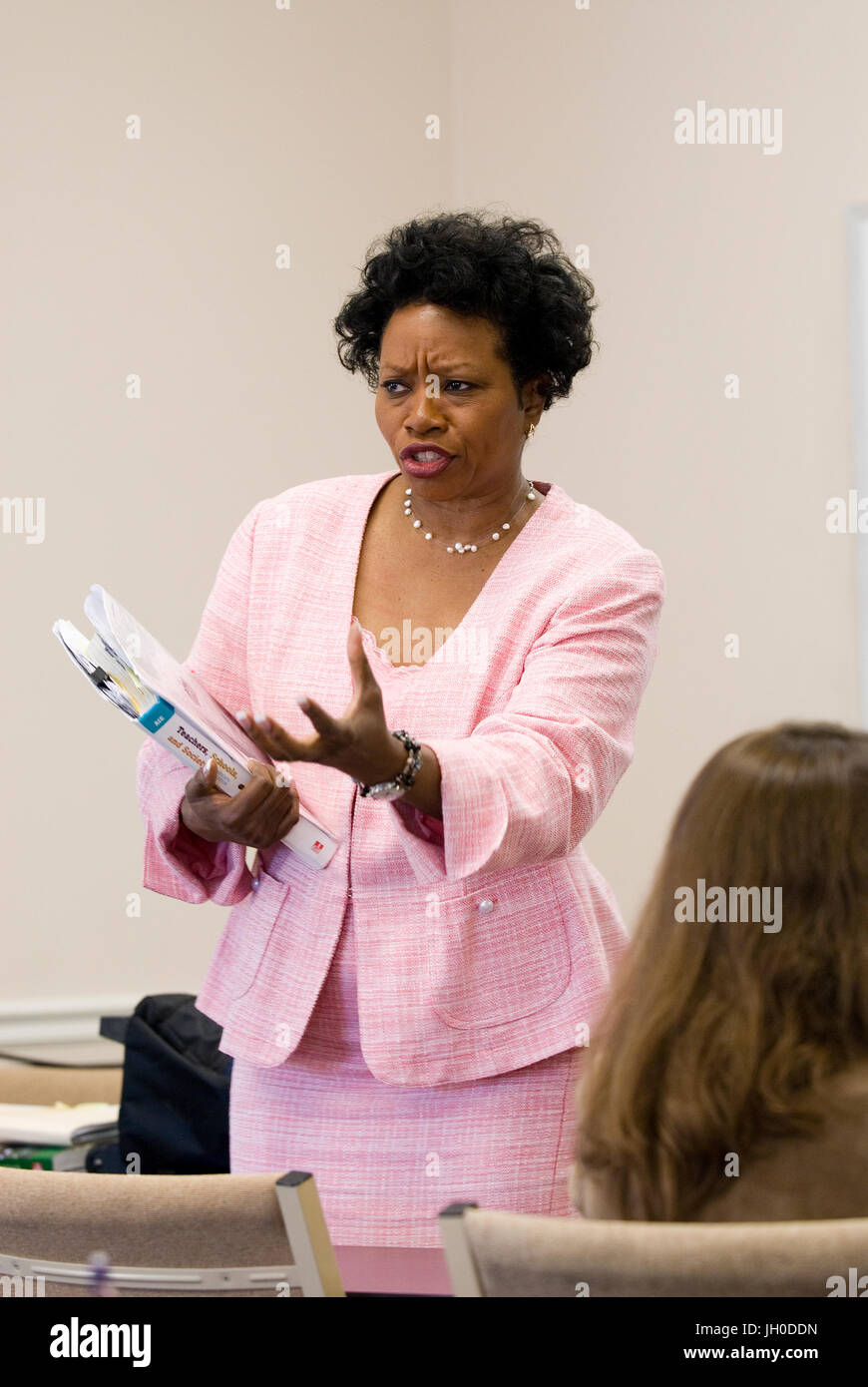 An African American professor teaches a class while standing at a ...