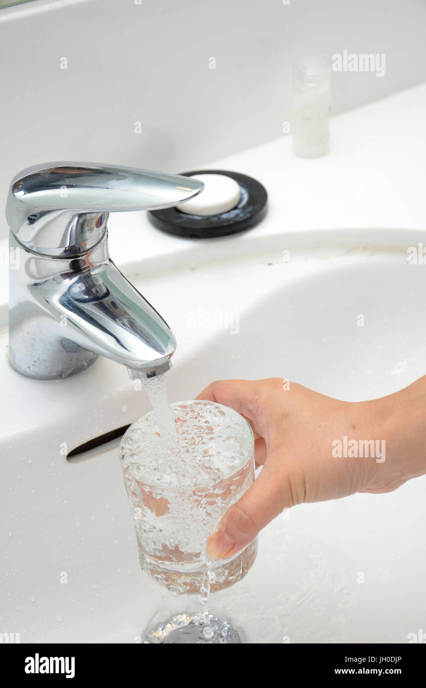 Filling a glass with water under the tap Stock Photo - Alamy