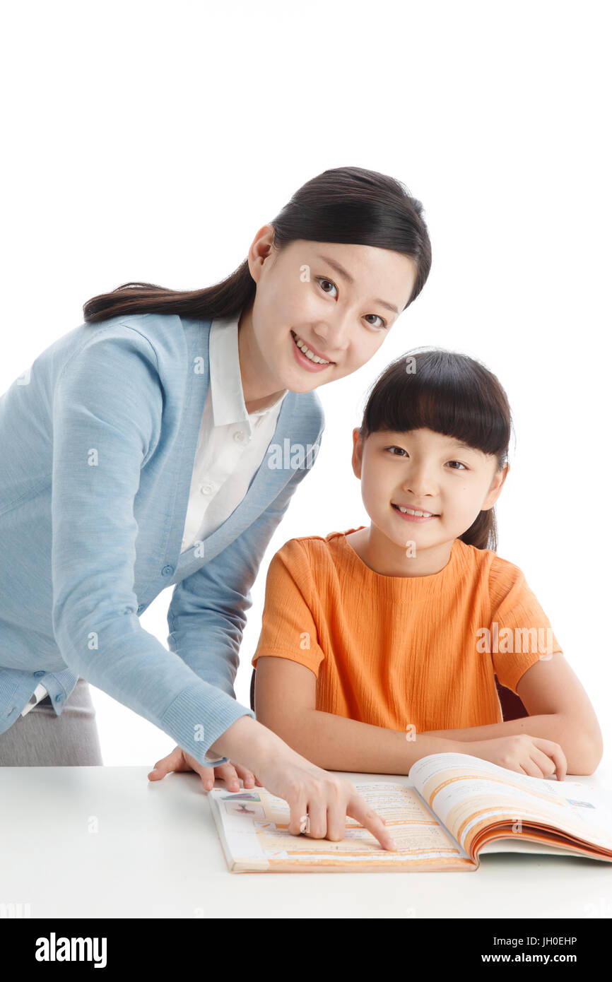 Female teacher helping school girl study Stock Photo - Alamy