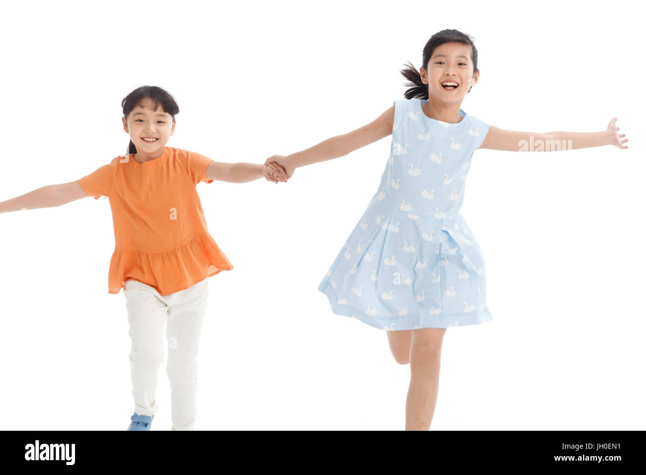 Two girl hand in hand running Stock Photo - Alamy