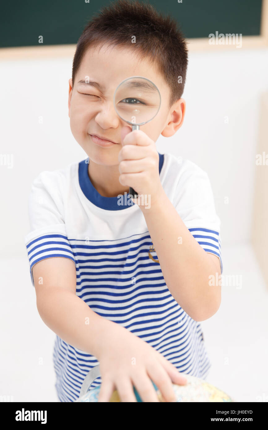 Primary school boys with a magnifying glass Stock Photo - Alamy