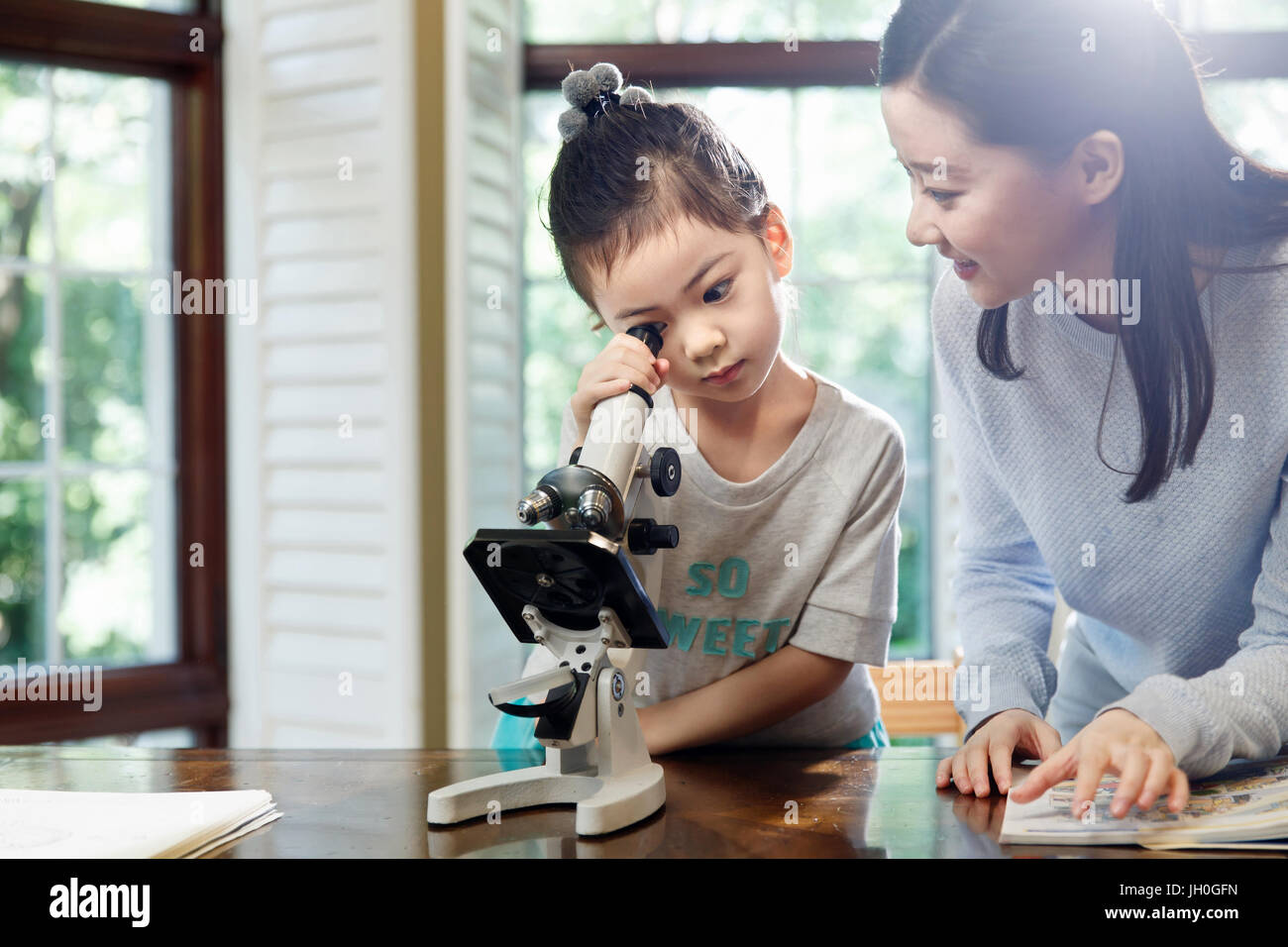 Mother and daughter using microscope Stock Photo - Alamy