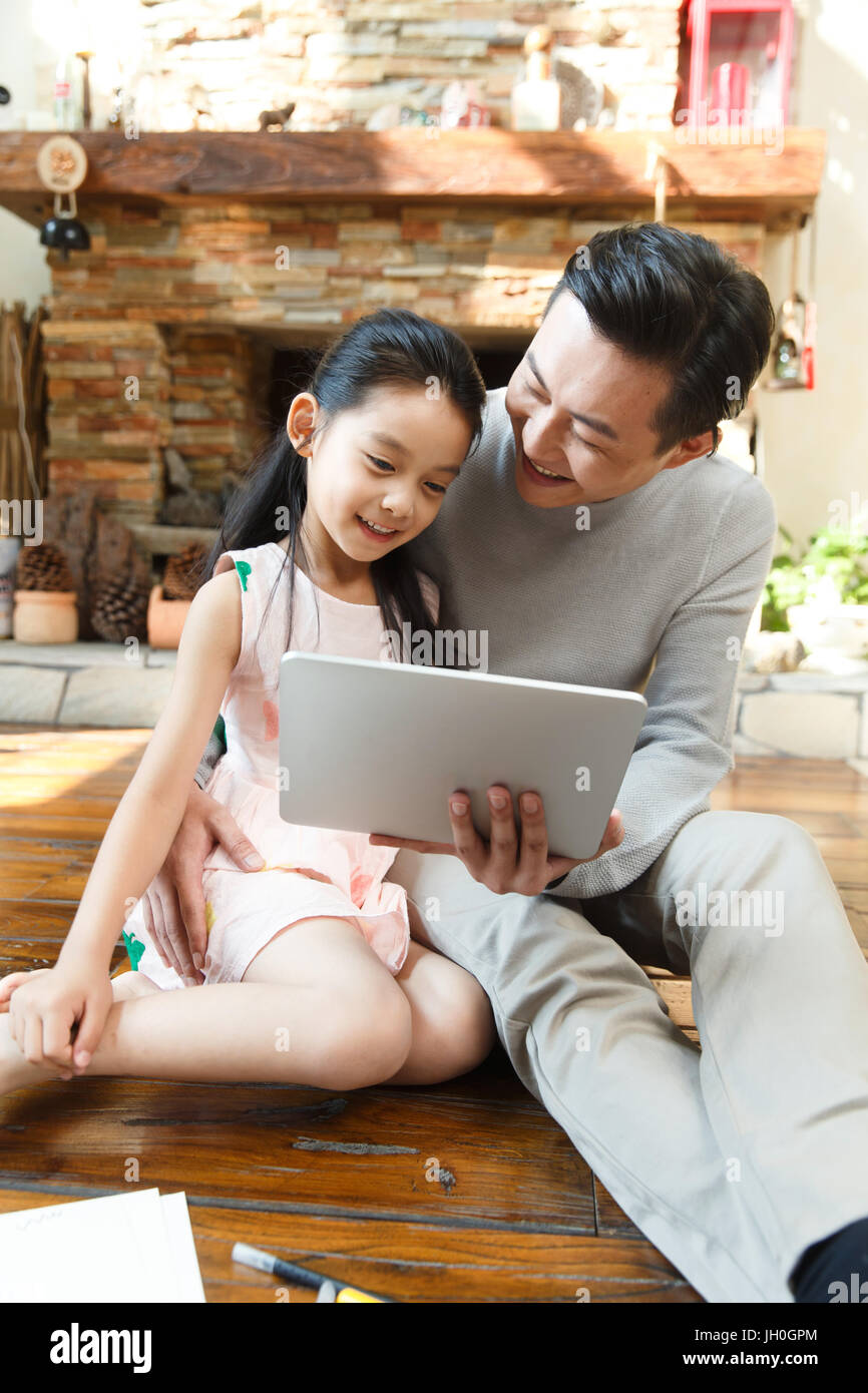 Father using digital tablet with daughter Stock Photo - Alamy