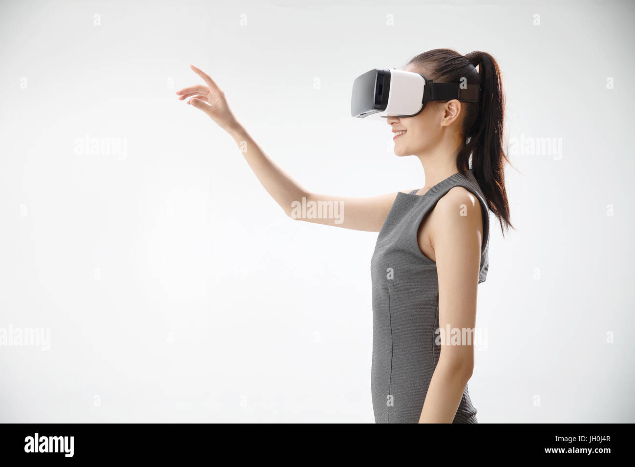 Young woman using virtual reality headset Stock Photo - Alamy