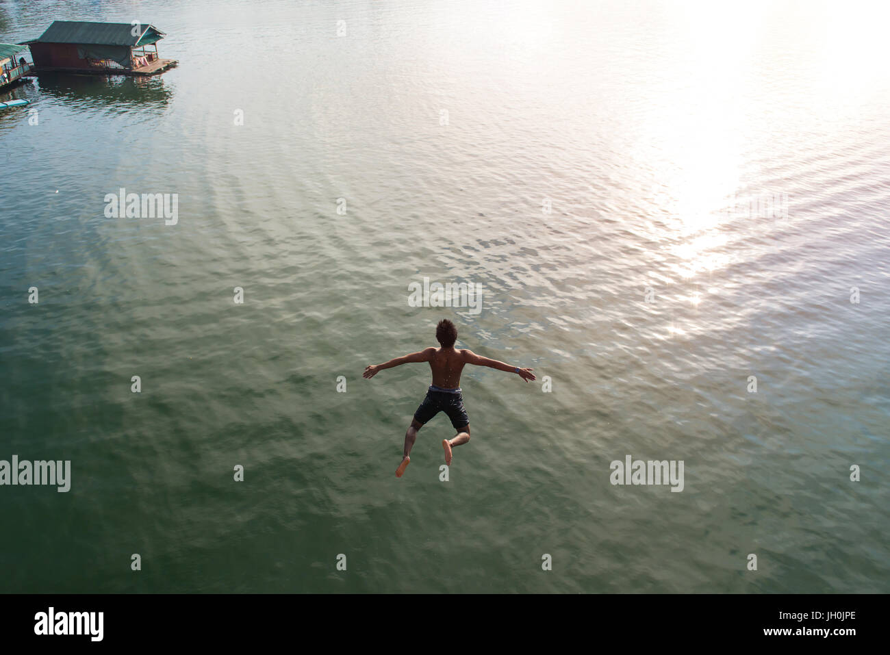 Man jumping into lake retro on Longest wooden bridge in sangkhlaburi ...