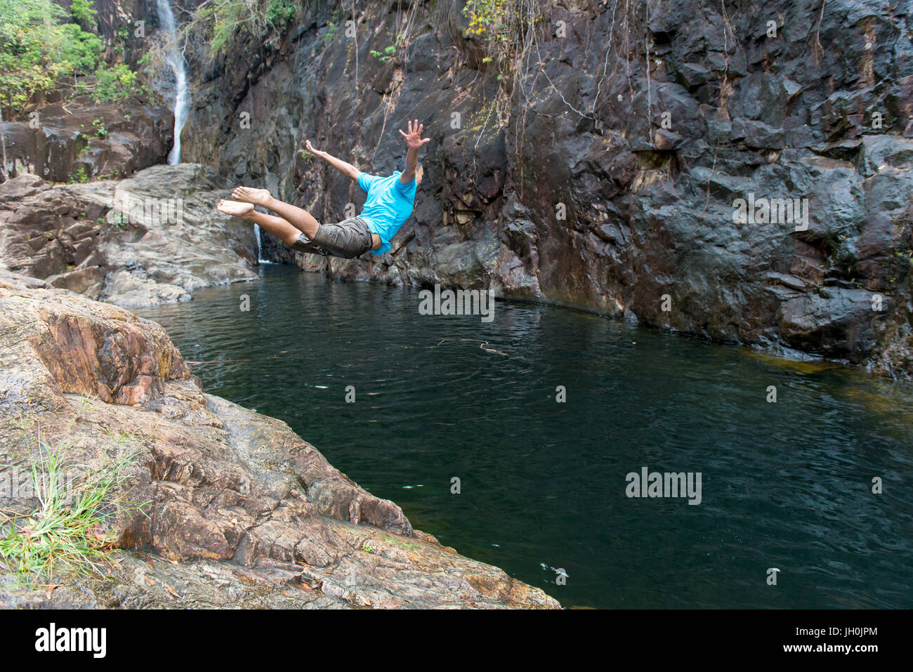 Man jumping on Waterfall in deep rain forest jungle Thailand Stock ...