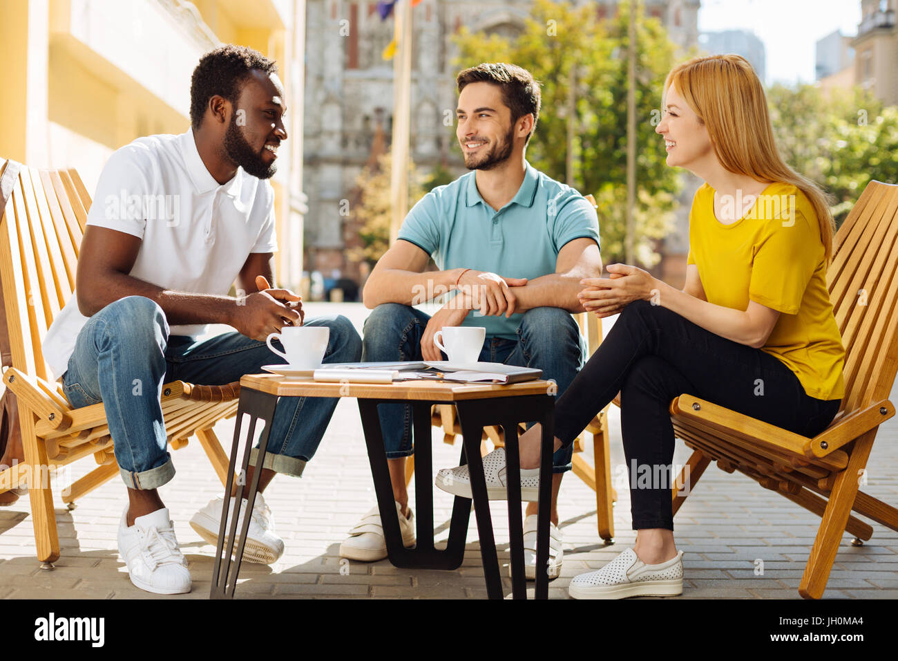 Easy going young people enjoying lovely conversation Stock Photo - Alamy