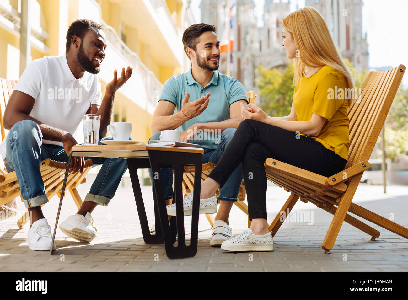 Two fun smart guys explaining their friend something Stock Photo - Alamy