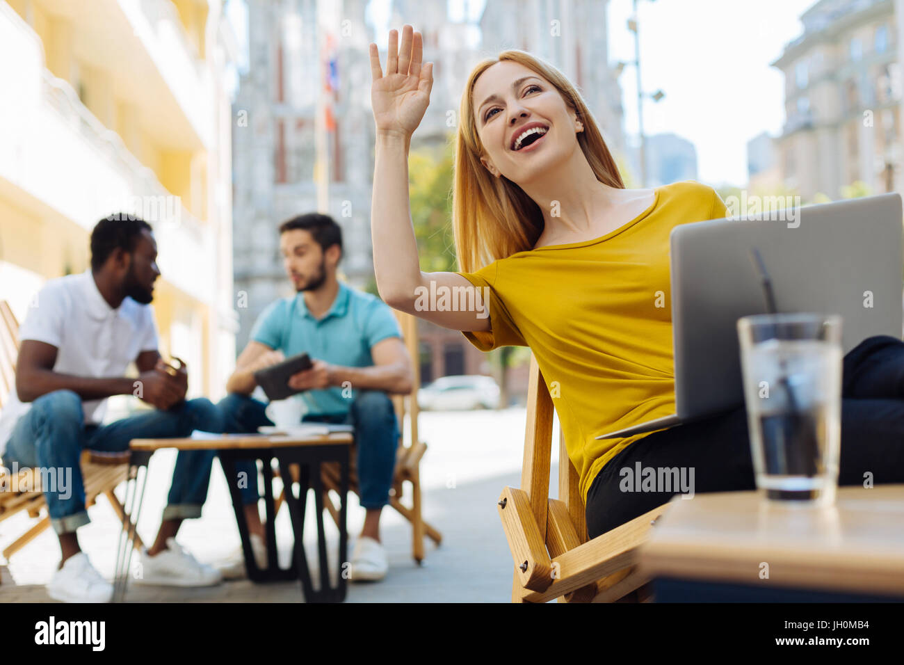 Enthusiastic fun woman waving at her friend Stock Photo - Alamy