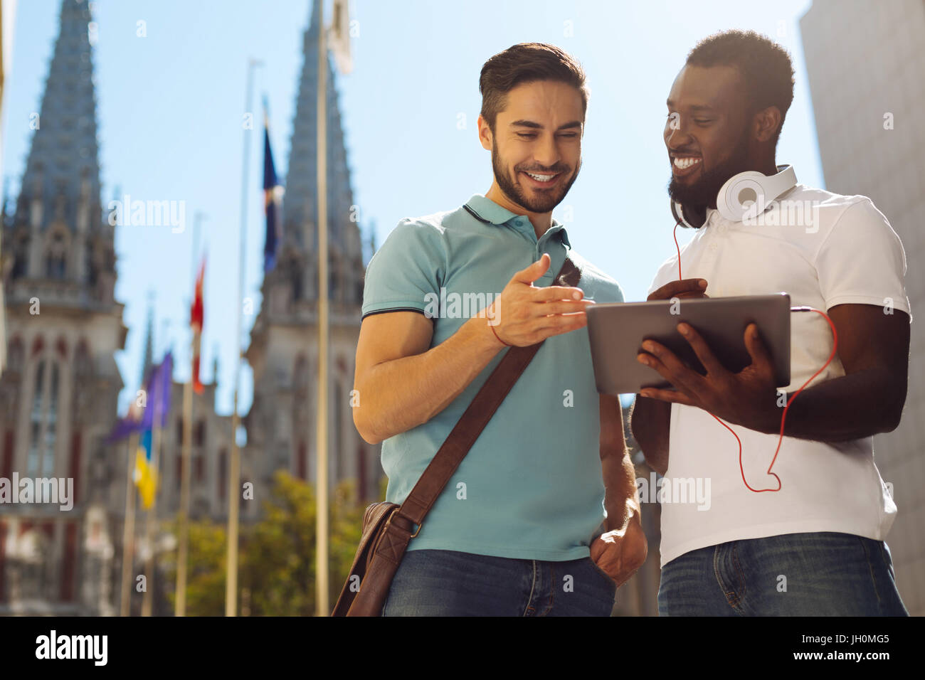 Enterprising remarkable guy showing his friend something Stock Photo ...
