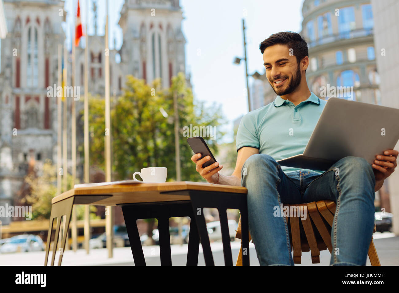 Positive confident guy smiling while reading the message Stock Photo ...