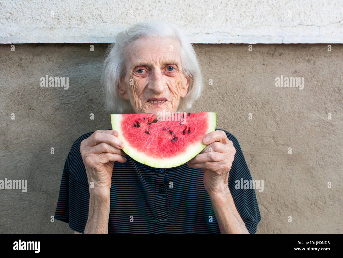 Senior woman eating watermelon fruit in the backyard Stock Photo - Alamy