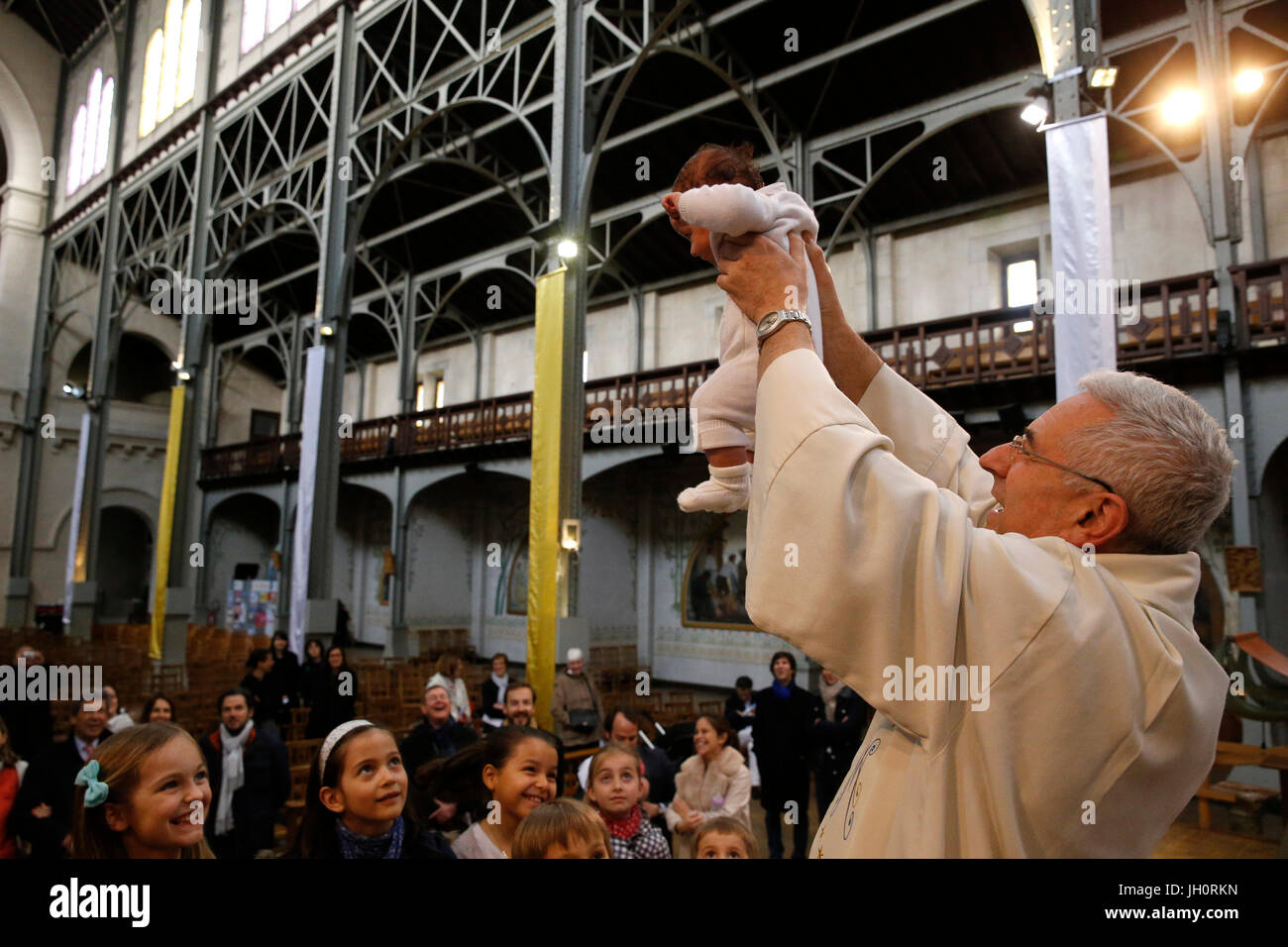 Baptism in a catholic church. Priest raising a baptised child. France ...