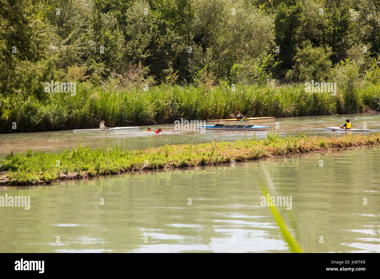 Overturned canoe / kayak in a river with people in the water trying to ...