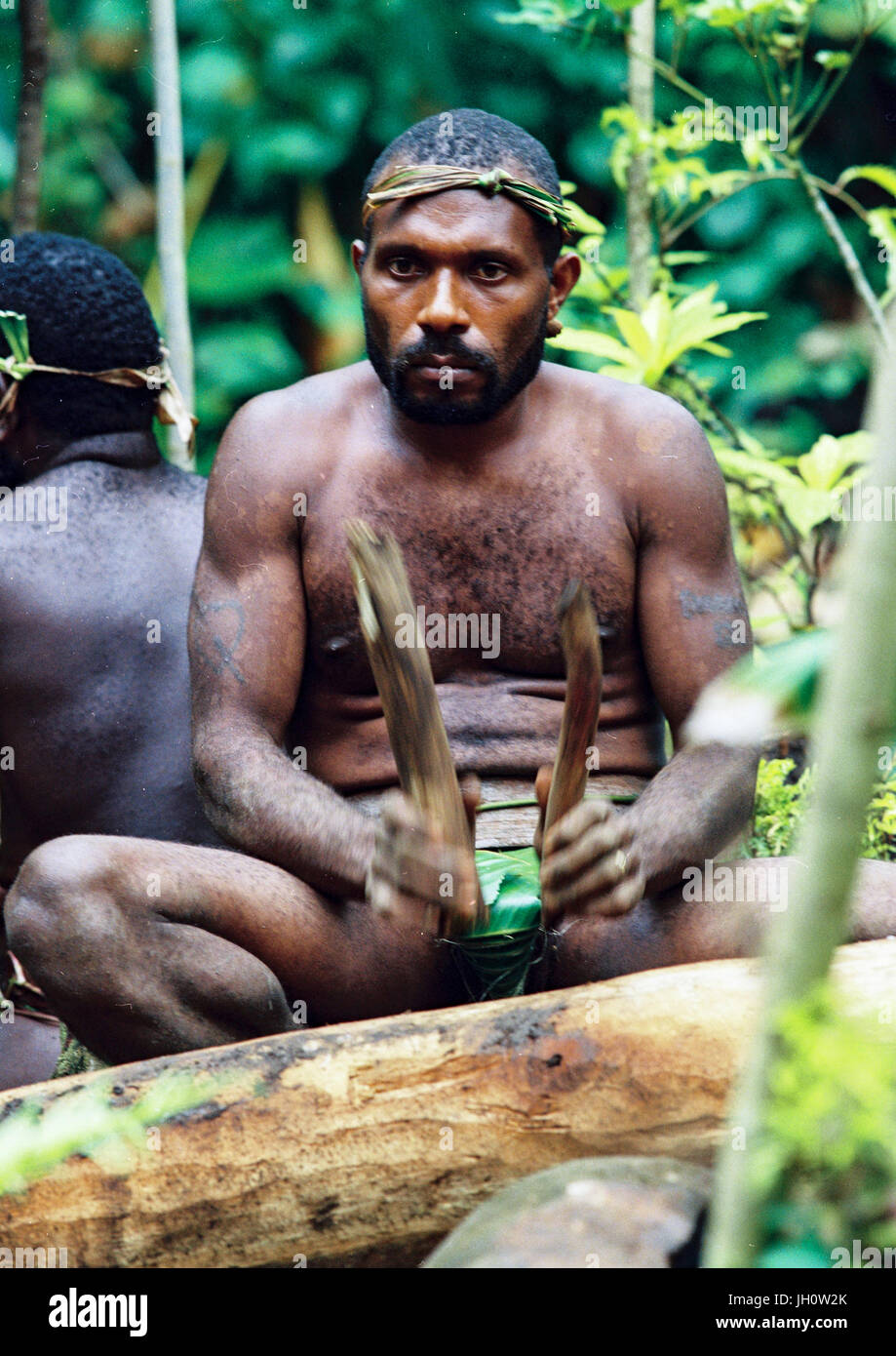 Tribesman beating a drum during a ceremony in the jungle, Malampa ...