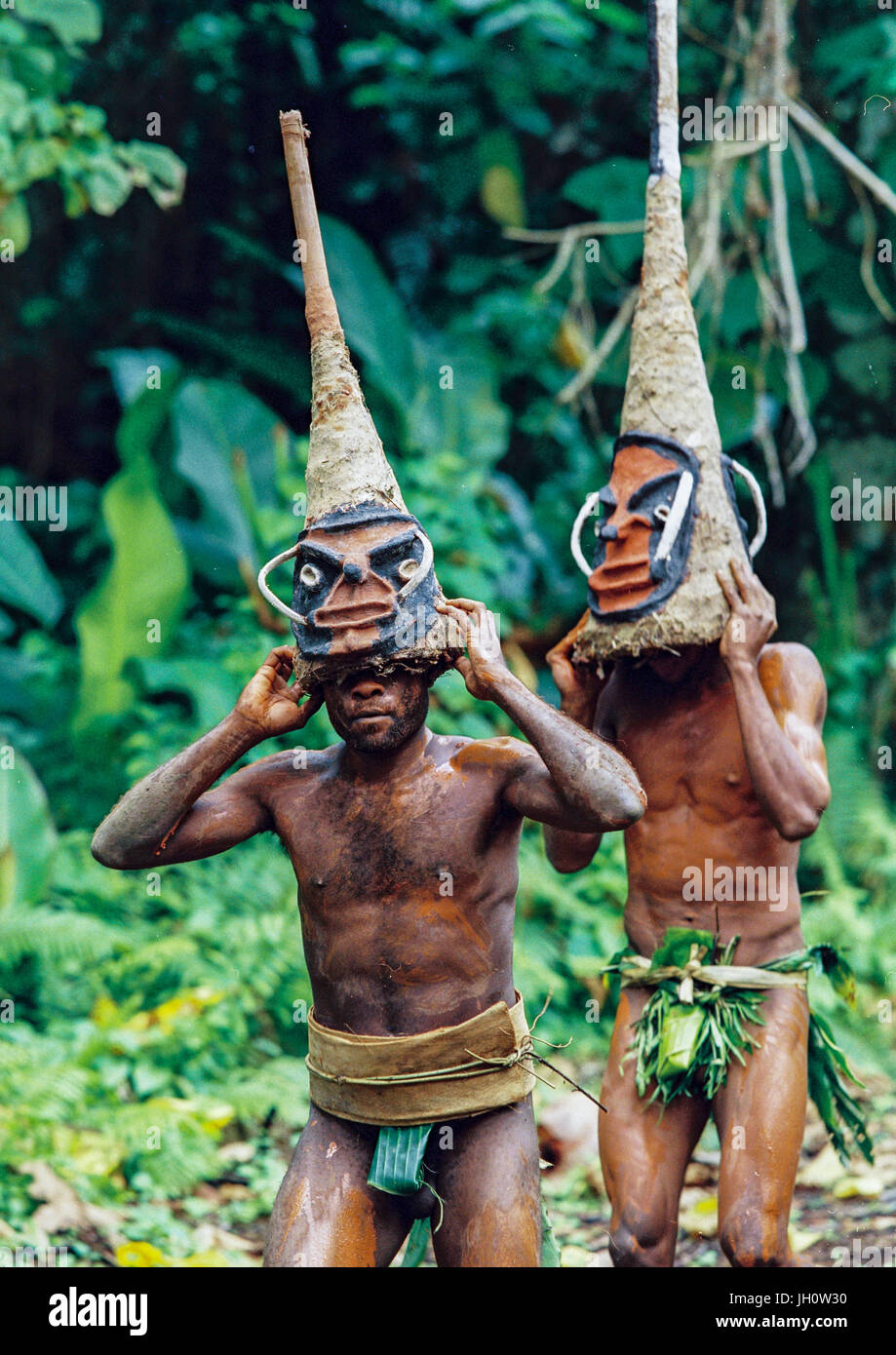 Tribesmen dancing in the jungle with helmet masks for a circumcision ...